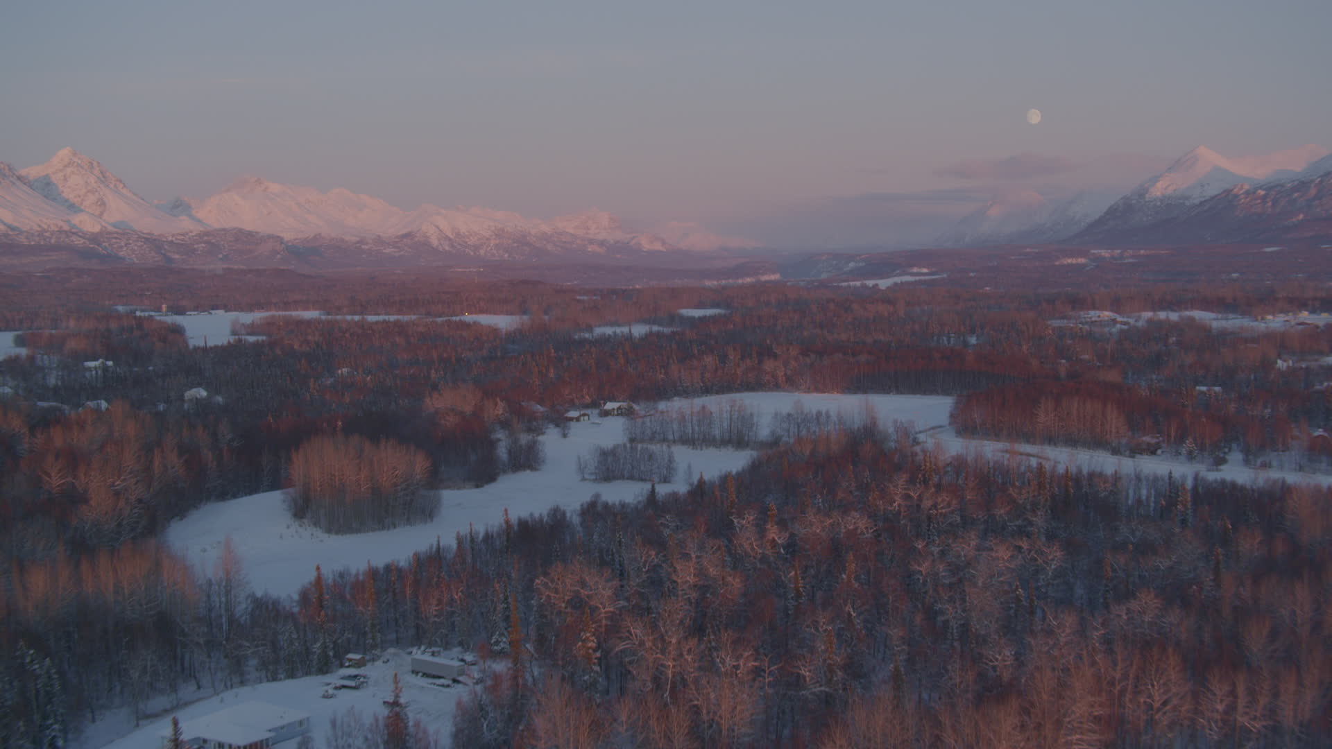 4K stock footage aerial video fly over snowy rural homes, reveal moon ...