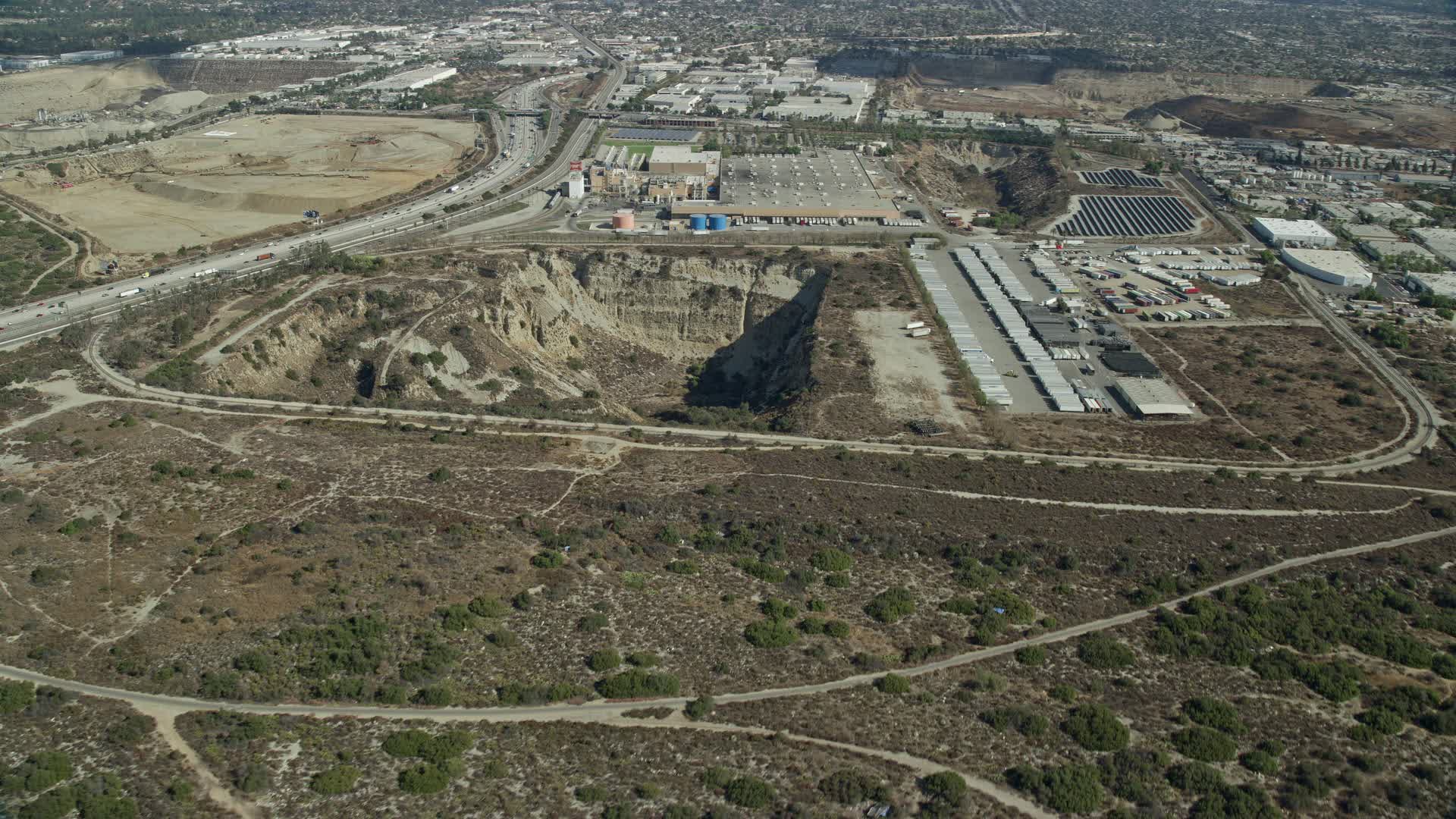 7.6K stock footage aerial video of an open pit next to a brewery in ...