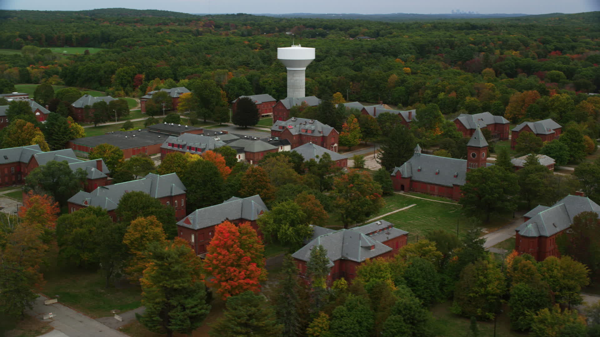 6K stock footage aerial video of a side view of Medfield State Hospital and water tower among ...