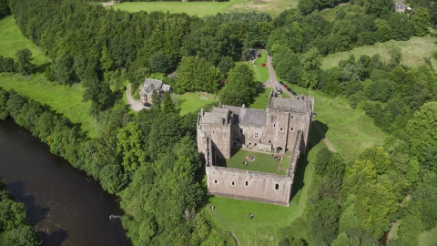 The iconic Doune Castle with trees along a river, Scotland Aerial Stock ...